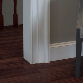 White Baseboard Trim with Dark Wood Door - Iowa Remodels